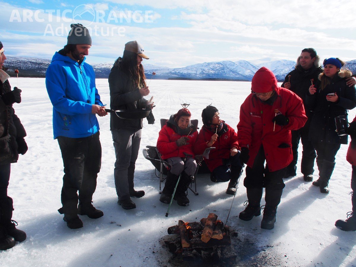 Group enjoying snacks around the campfire | Arctic Range Adventure