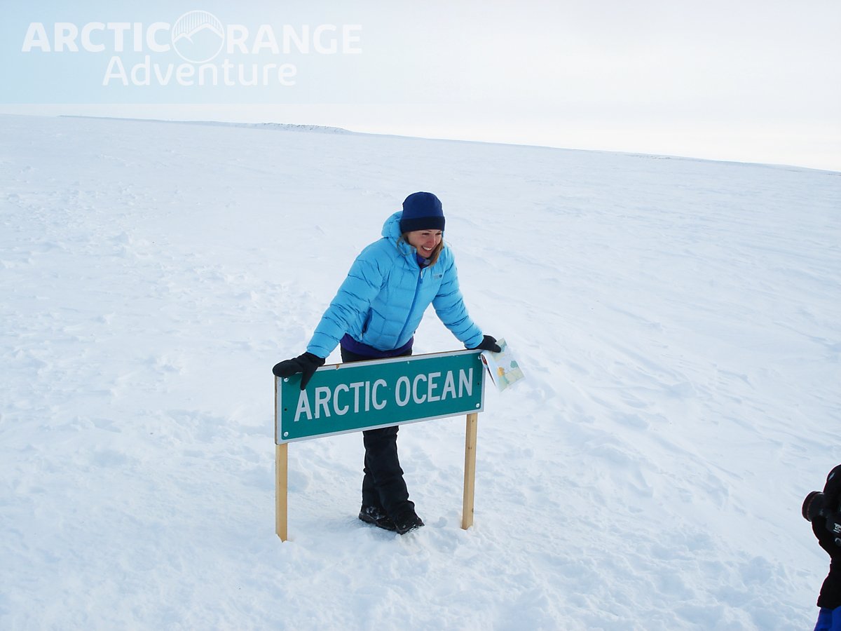 Guest at the Arctic Ocean sign | Arctic Range Adventure